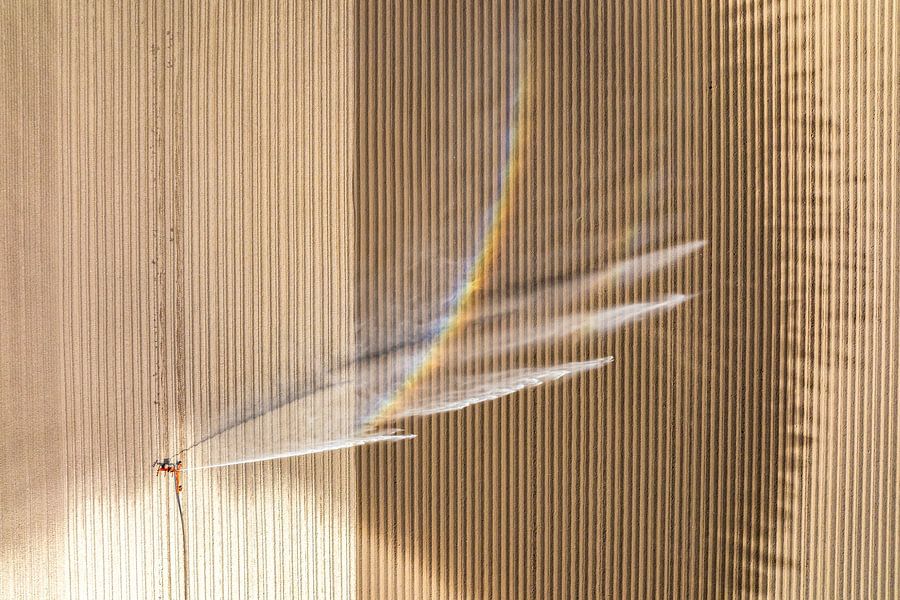 Waterkanon sproeit water op een veld van boven gezien van Sjoerd van ...