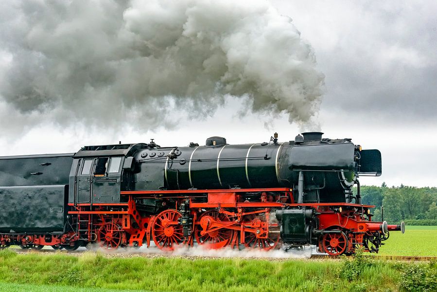 Old steam locomotive pulling railway cars driving through the ...