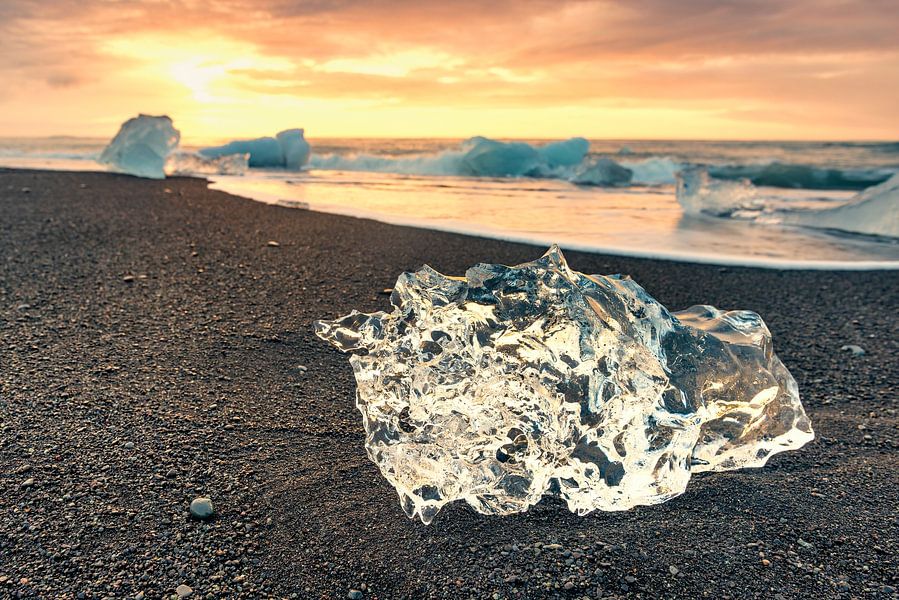 IJsblok op het strand van Jökulsárlón tijdens zonsondergang in IJsland ...